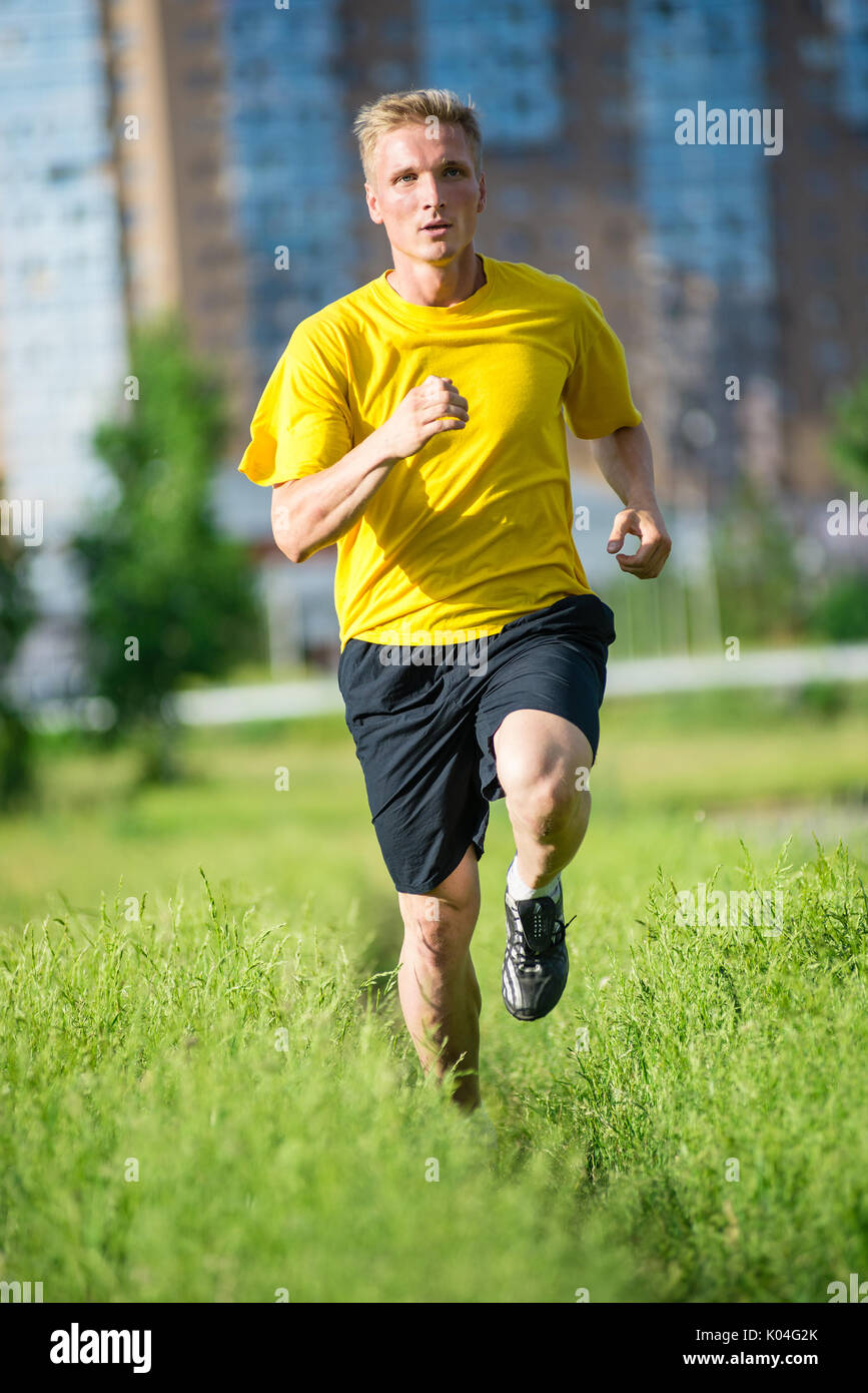Sporty man jogging in city street park. Outdoor fitness Stock Photo - Alamy
