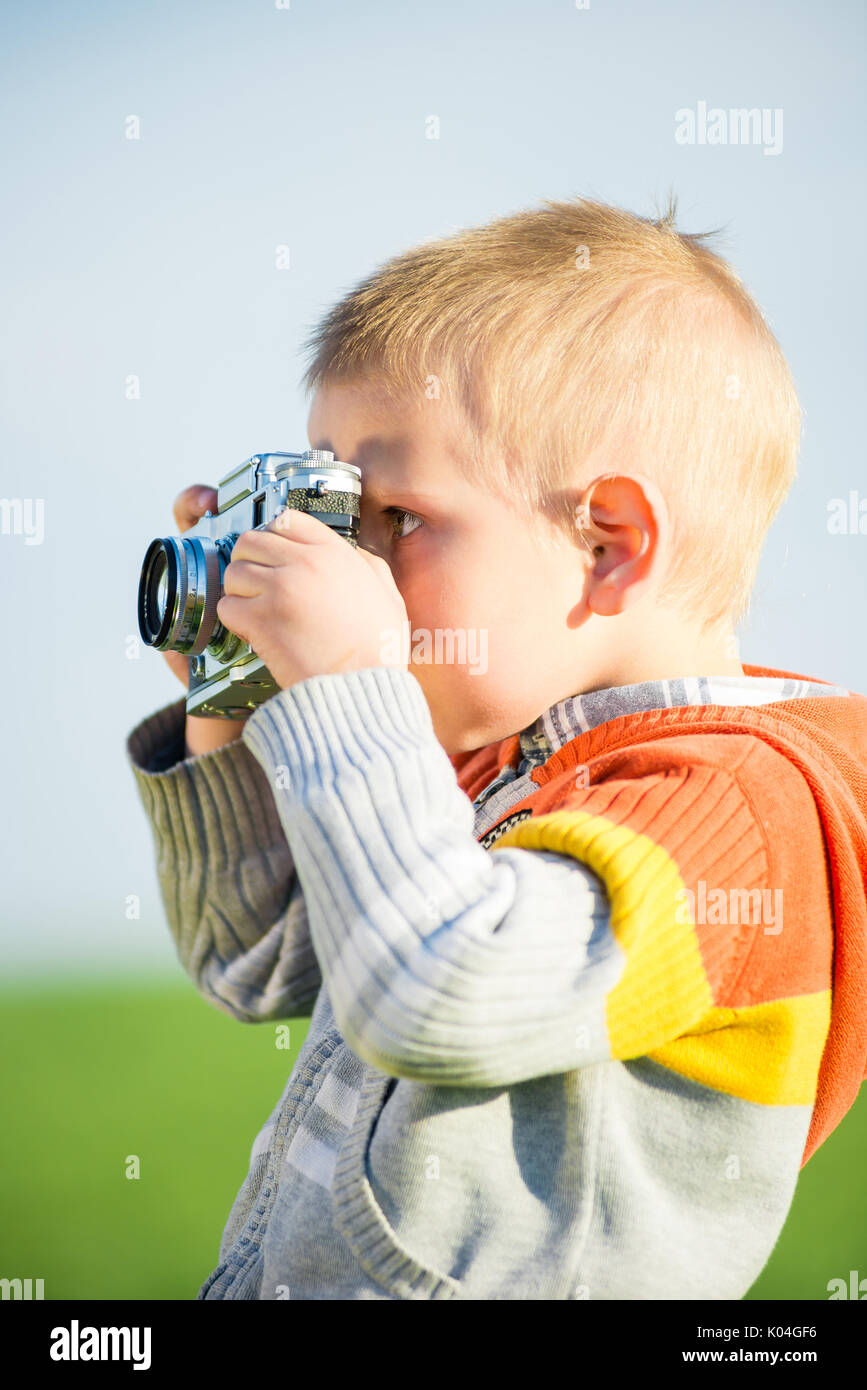 Little boy with an old camera shooting outdoor Stock Photo - Alamy