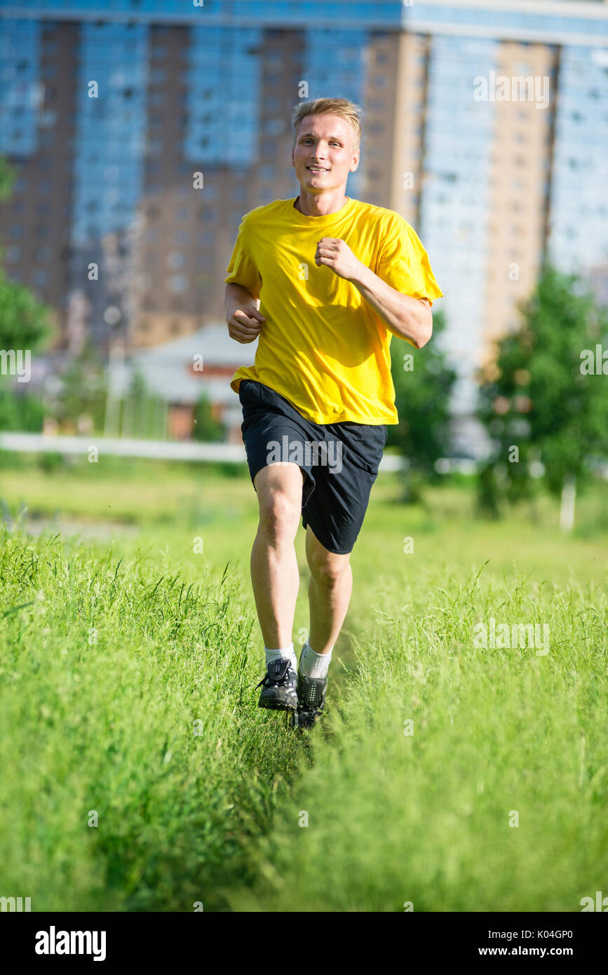 Sporty man jogging in city street park. Outdoor fitness Stock Photo - Alamy