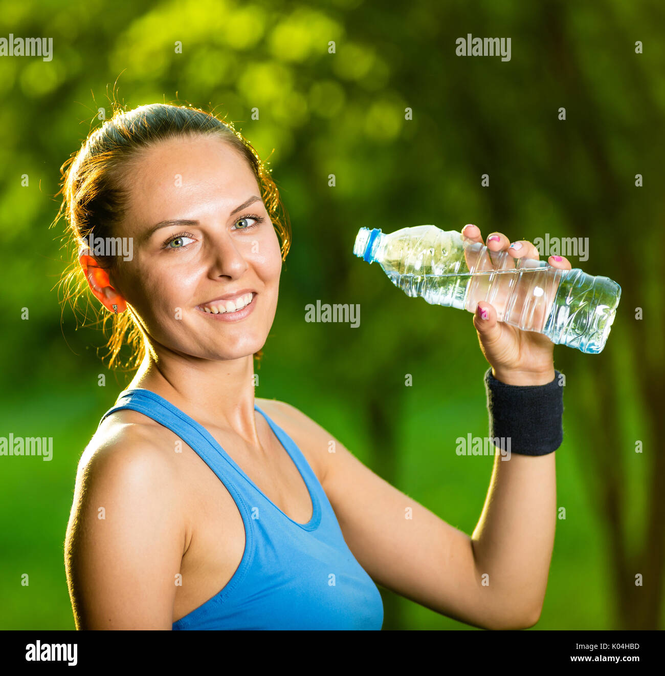 Young woman drinking water after fitness exercise Stock Photo - Alamy