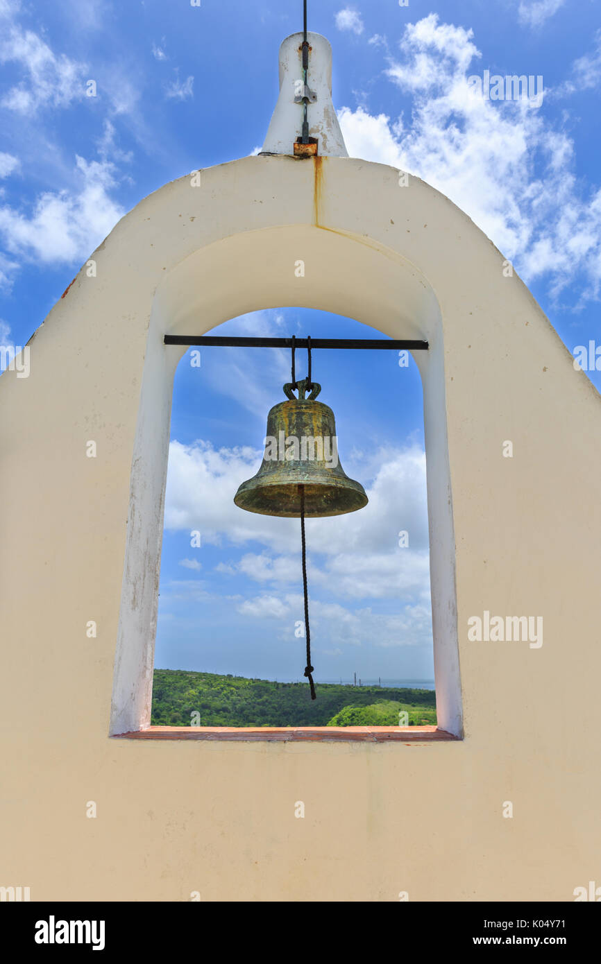 Church bell, exterior bronze bell in window against blue summer sky ...