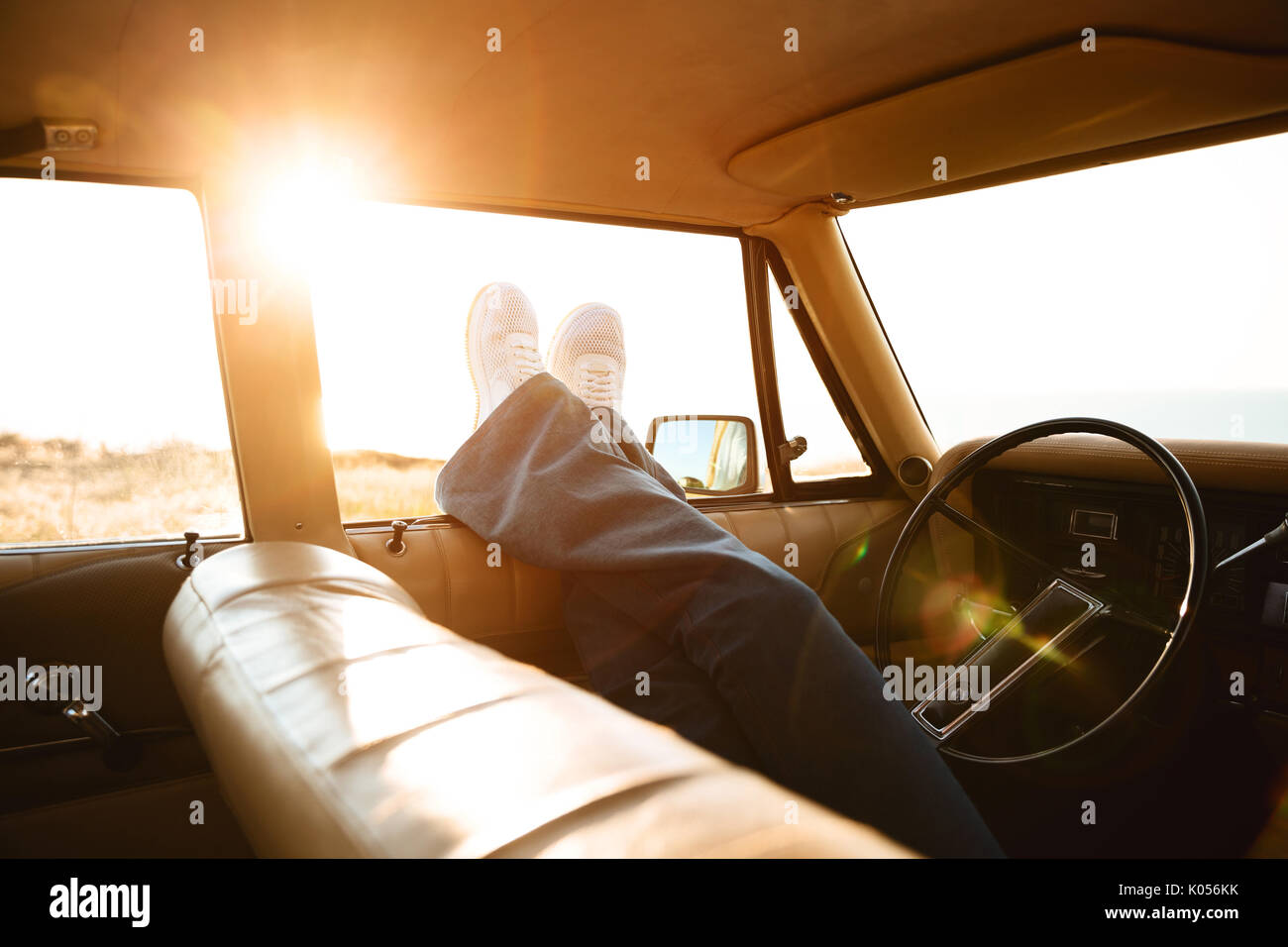 Female legs leaning out of the car window. view from inside of a car ...