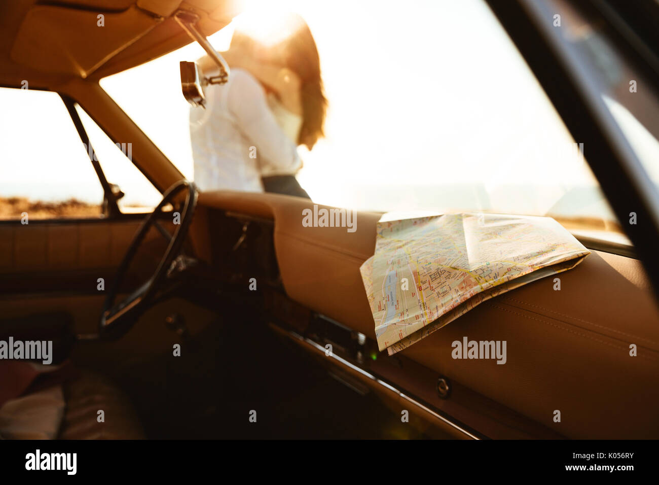 Young attractive couple hugging while standing outside and leaning on a ...