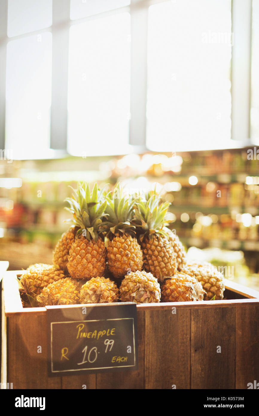 Pineapples on display in grocery store market Stock Photo - Alamy