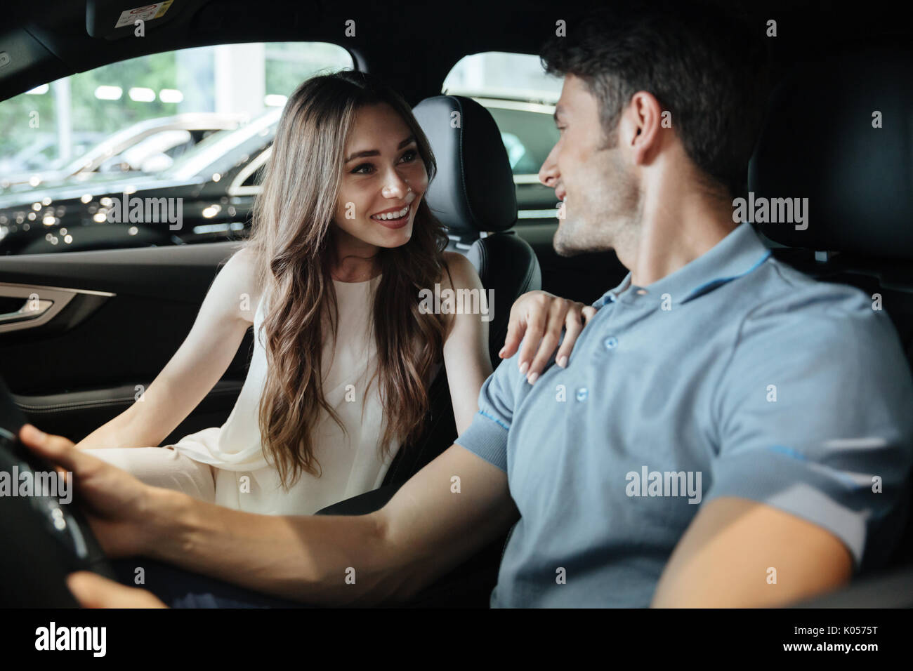Young couple sitting inside new car at dealership center Stock Photo ...
