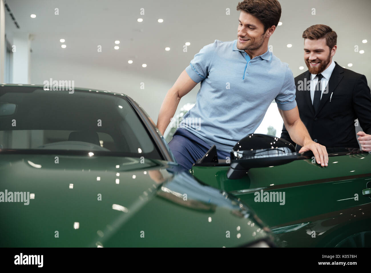 Young male customer getting inside his new car at the dealership Stock ...