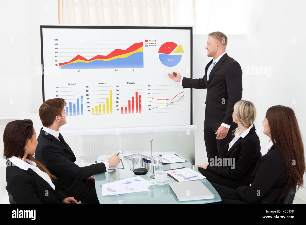 Businessman explaining project to colleagues in conference meeting at ...