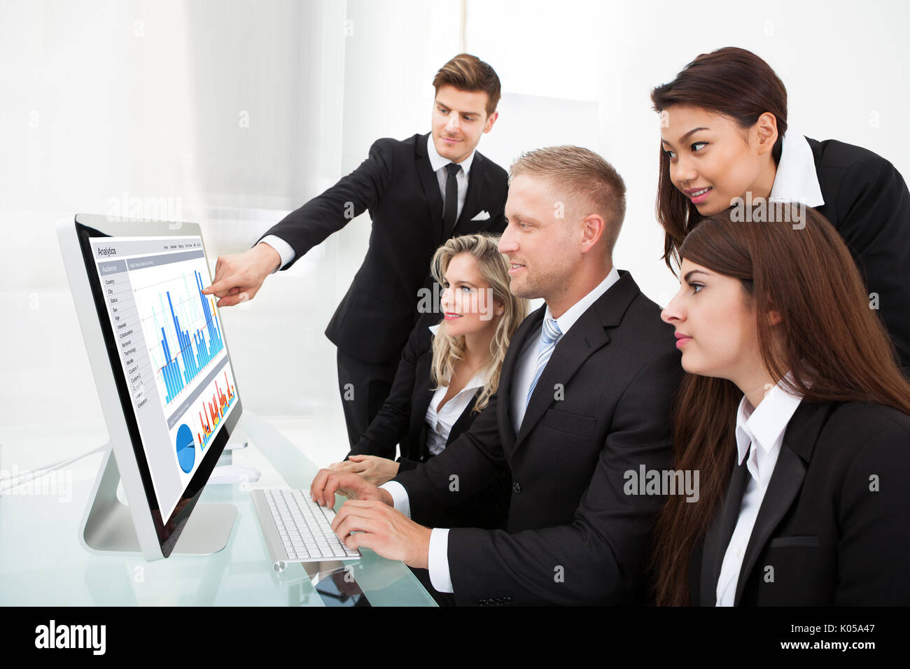 Group of businesspeople using desktop PC together in office Stock Photo ...