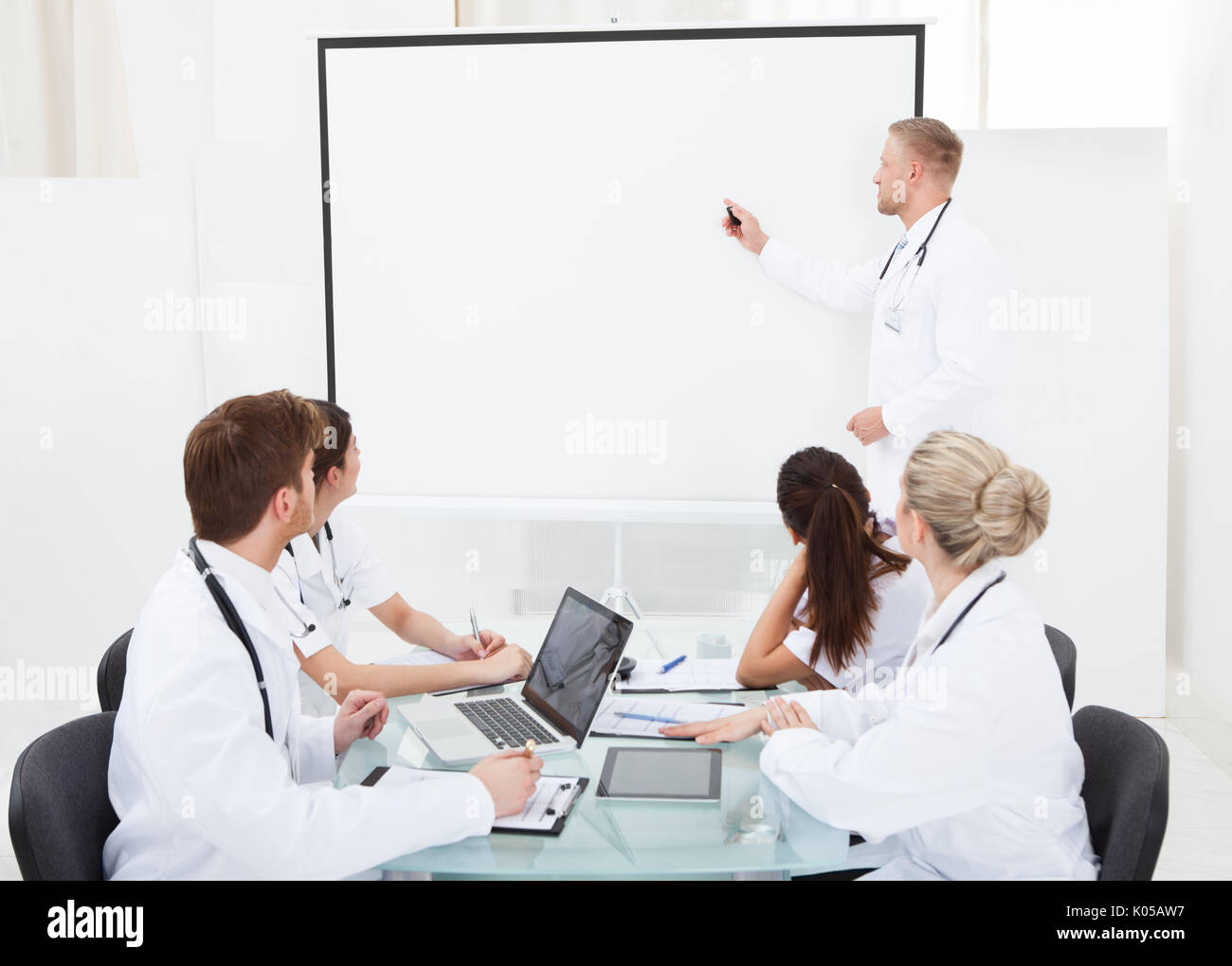 Doctor giving presentation to colleagues in meeting at hospital Stock ...