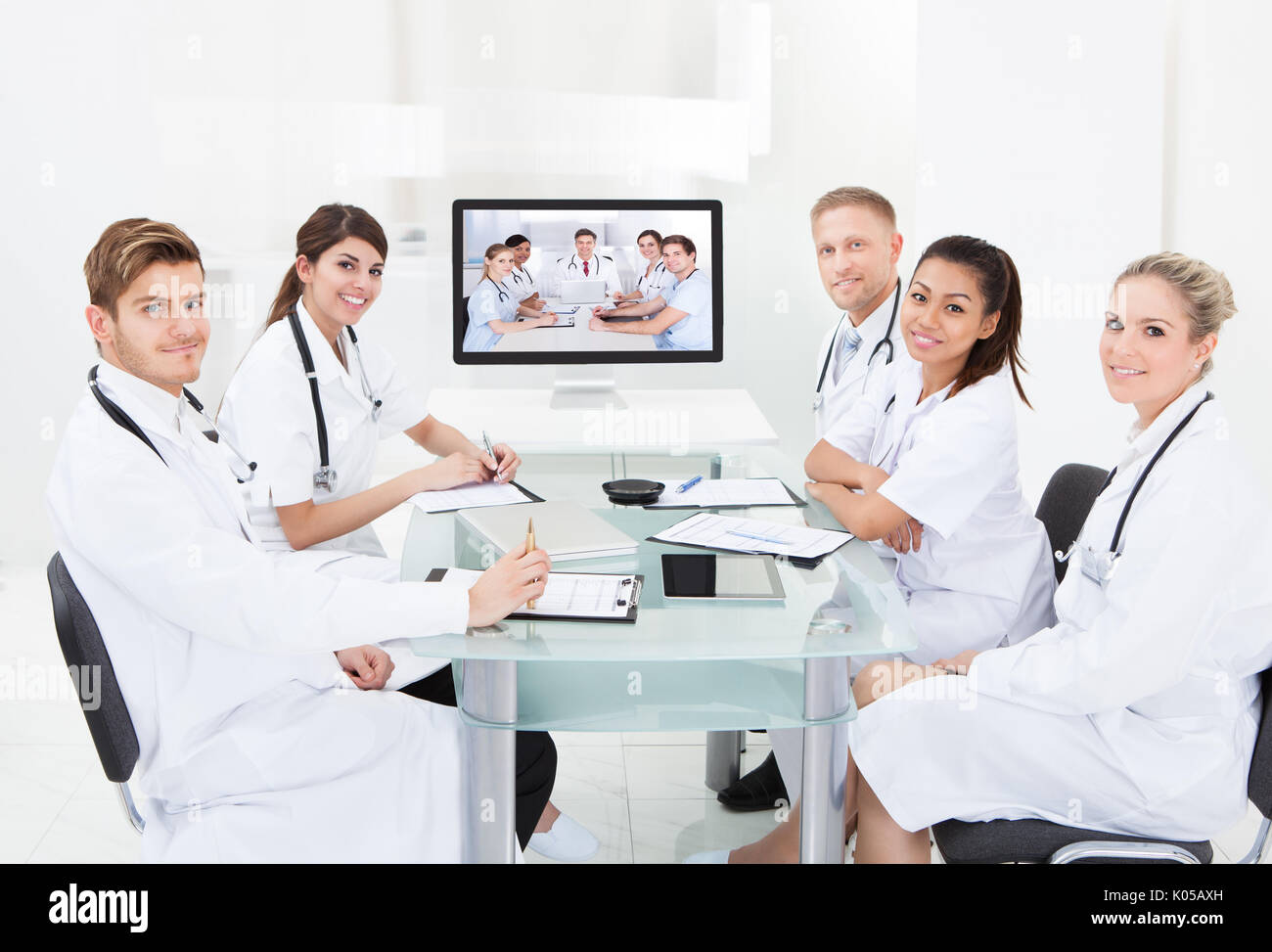 Team of doctors attending video conference at desk in hospital Stock ...