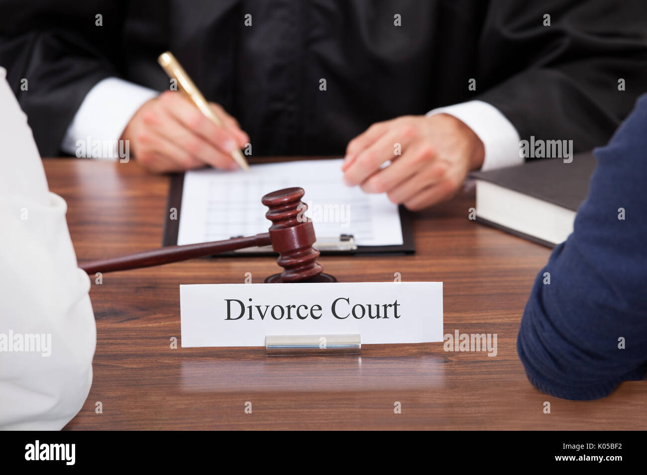 Cropped image of couple with judge writing at desk in court Stock Photo ...
