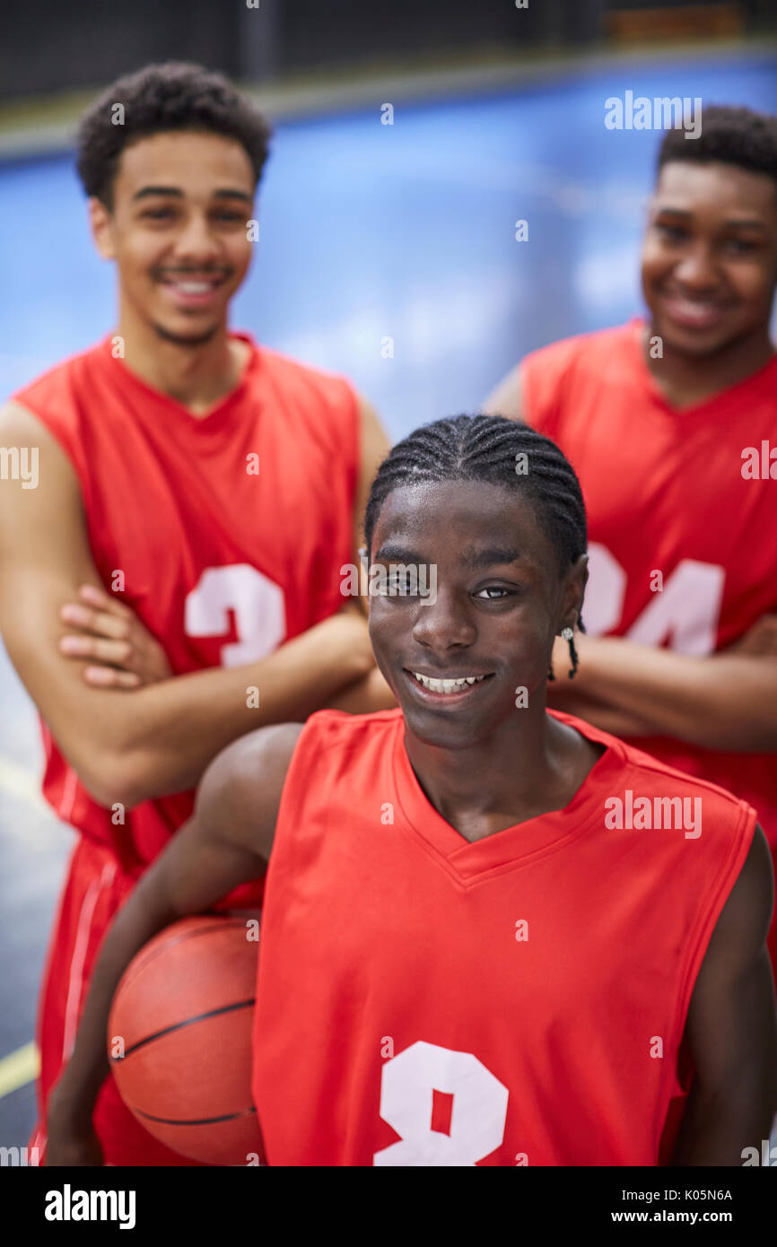 Portrait smiling, confident young male basketball player team in red ...