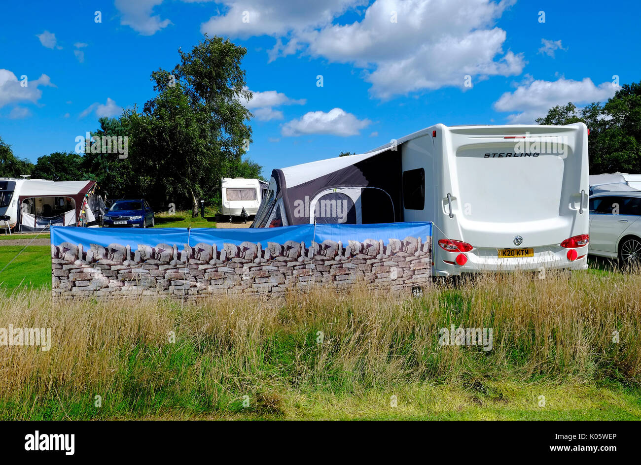 caravan on campsite with stone wall wind break Stock Photo - Alamy