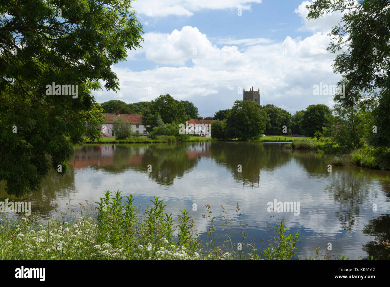 Cottages and the village church viewed across the large pond that forms ...