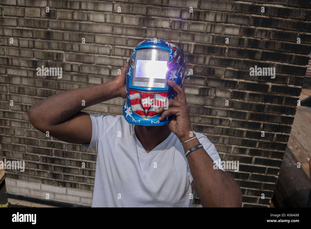 New York, New York, USA. 21st Aug, 2017. A rooftop welder looks up at ...