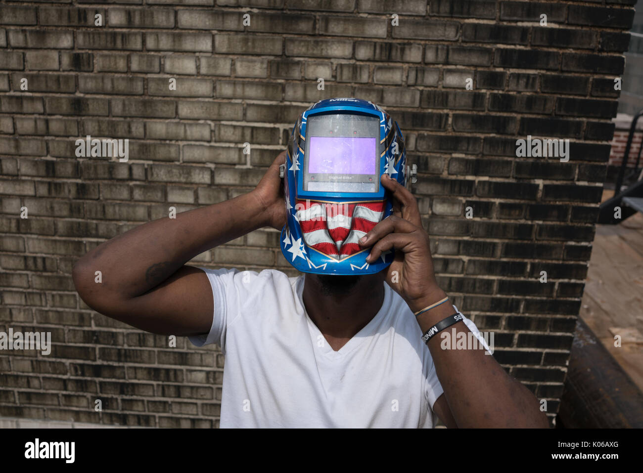 New York, New York, USA. 21st Aug, 2017. A rooftop welder looks up at ...