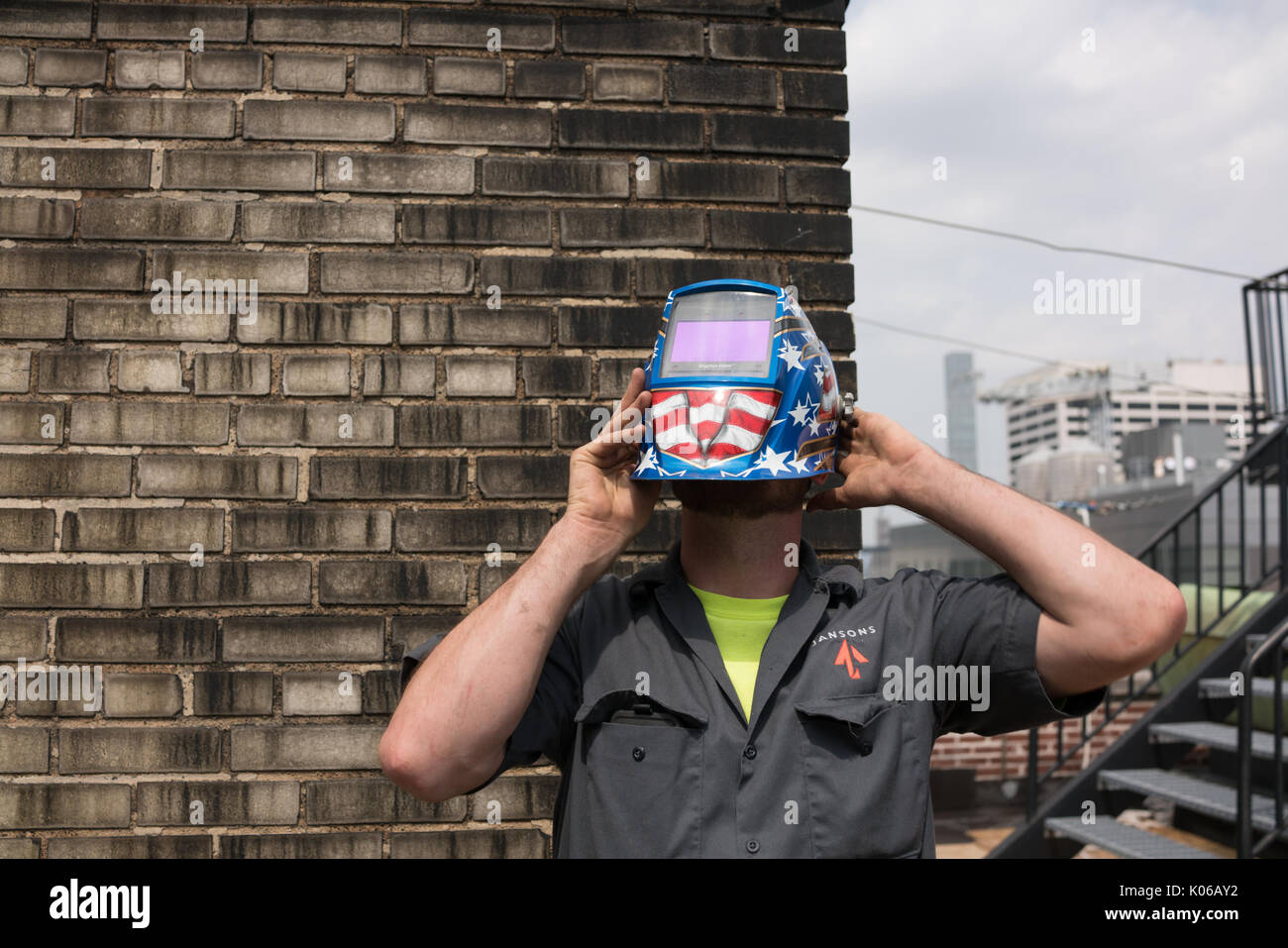 New York, New York, USA. 21st Aug, 2017. A rooftop welder looks up at ...