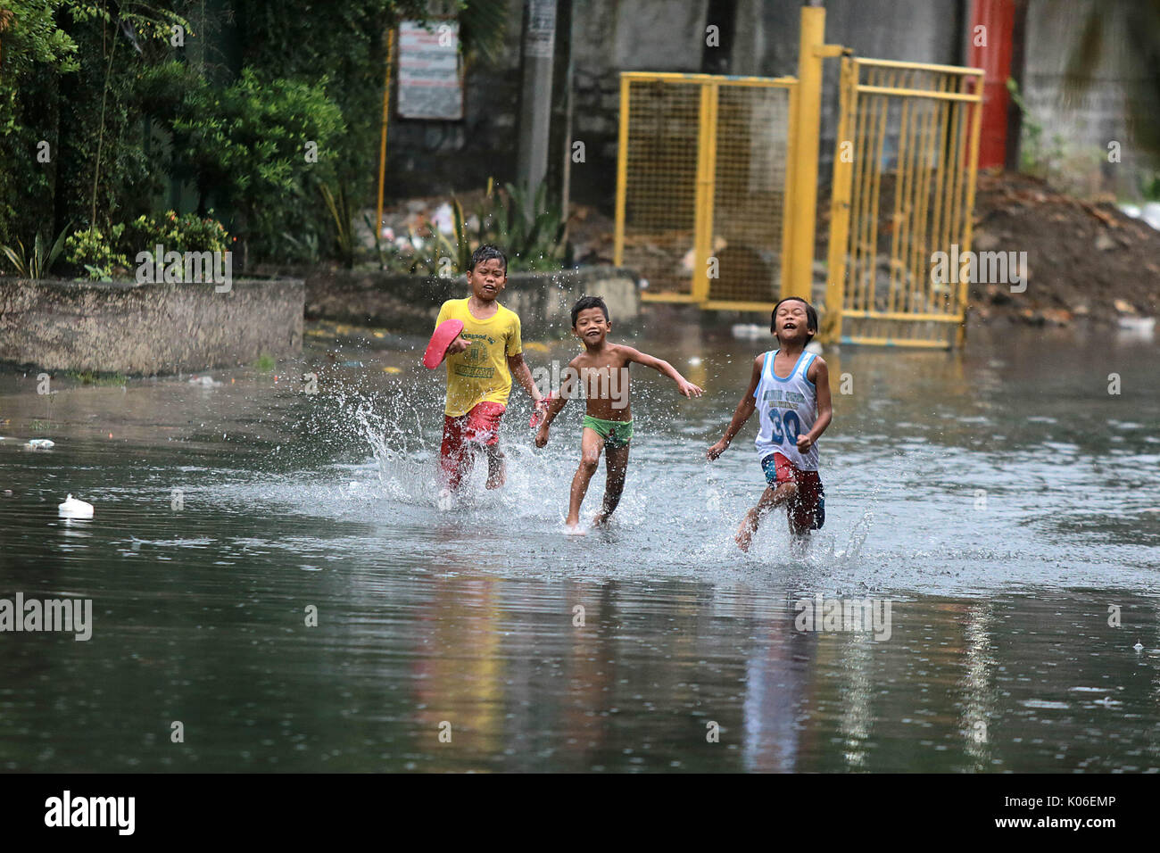 Makati City, Philippines. 22nd Aug, 2017. Children play on a flooded ...