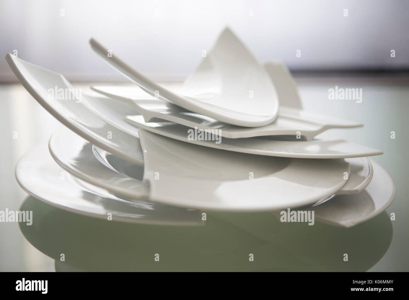 pile of broken white plates on glass table Stock Photo - Alamy
