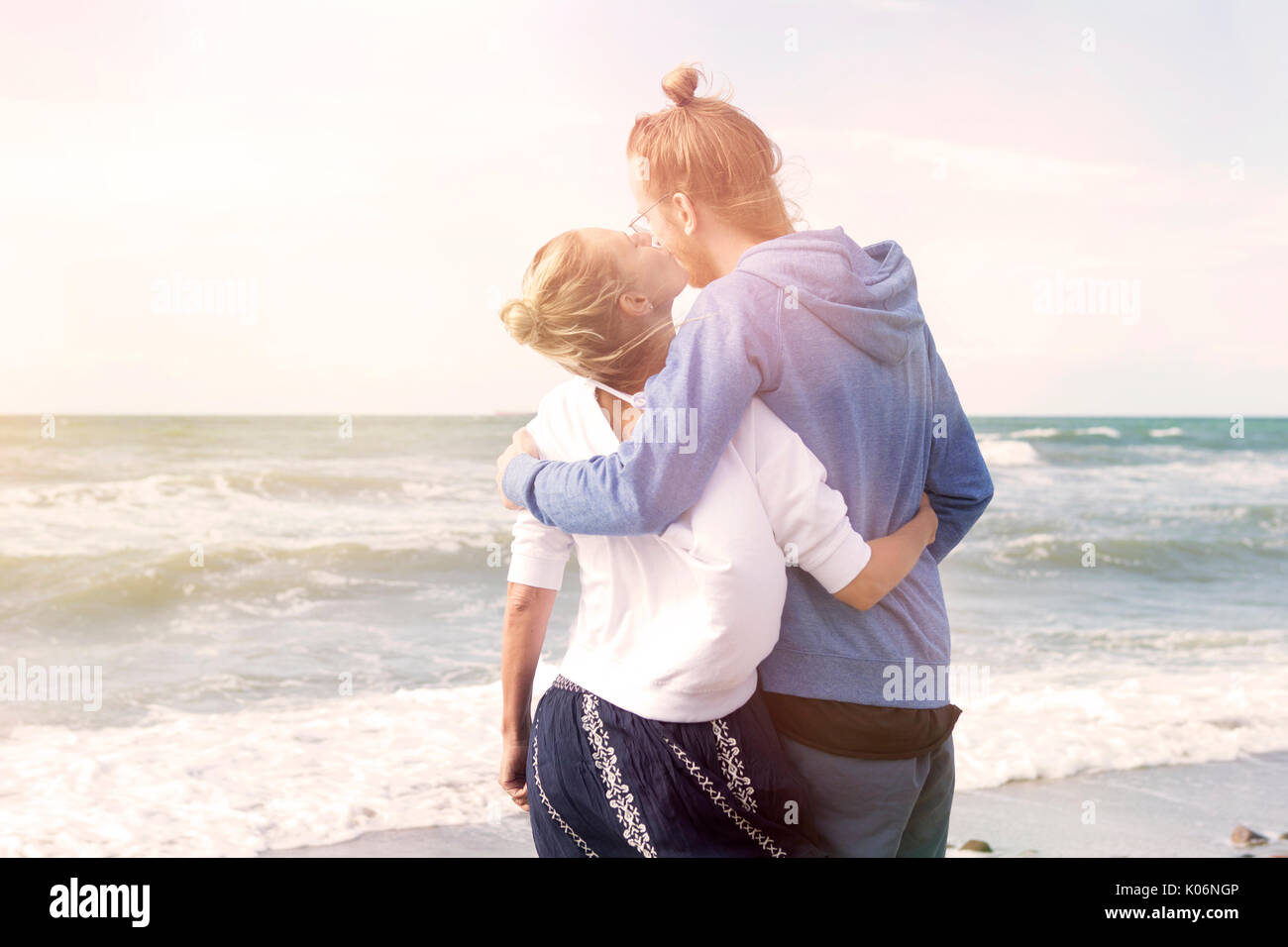 young couple by the ocean hugging each other Stock Photo - Alamy