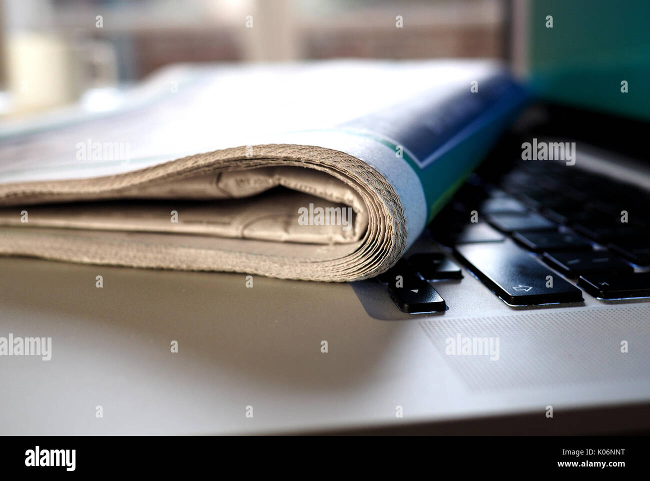 Newspaper on keyboard of laptop Stock Photo - Alamy
