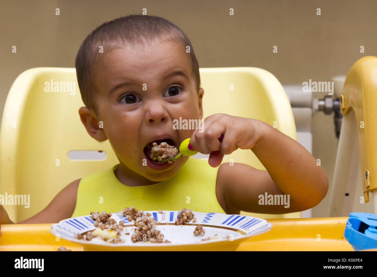 smiling cute baby kid boy eating itself with spoon Stock Photo - Alamy