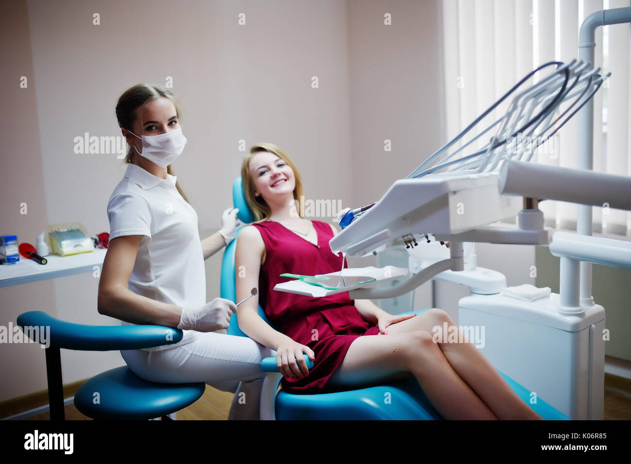 Beuatiful female dentist posing and smiling with her lovely patient ...