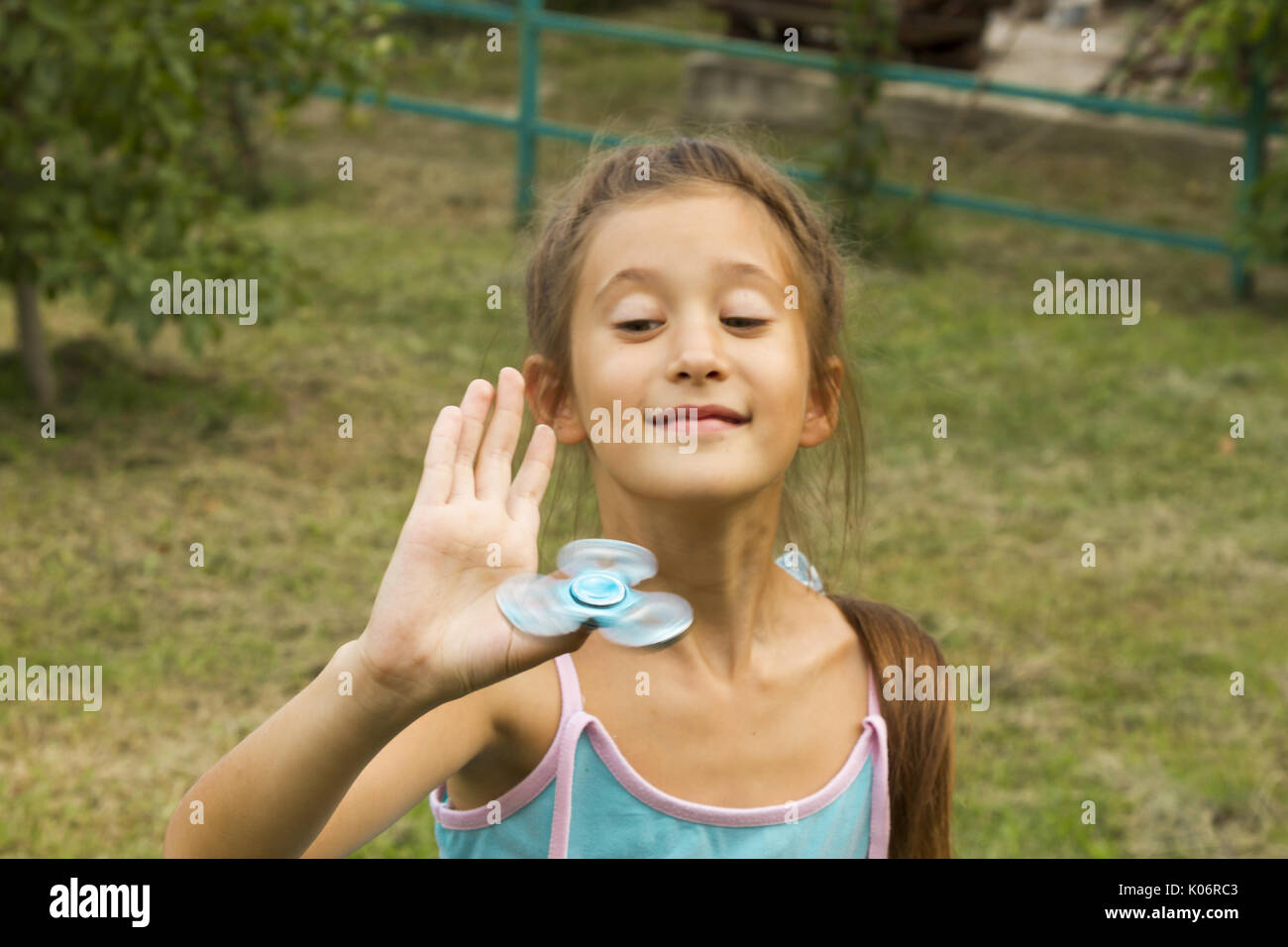 little girl having fun with golden fidget spinner, child with spinner ...