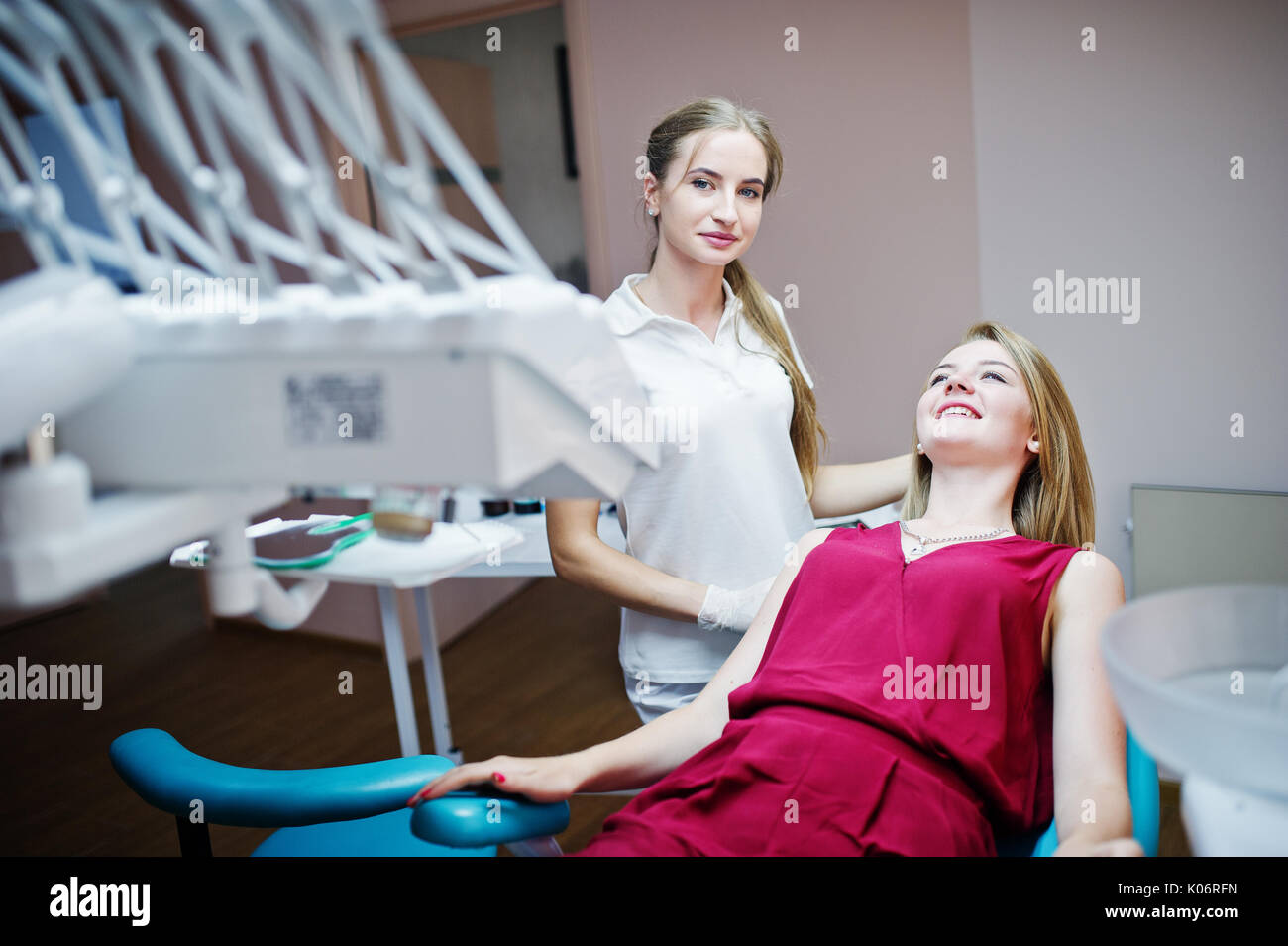 Beuatiful female dentist posing and smiling with her lovely patient ...