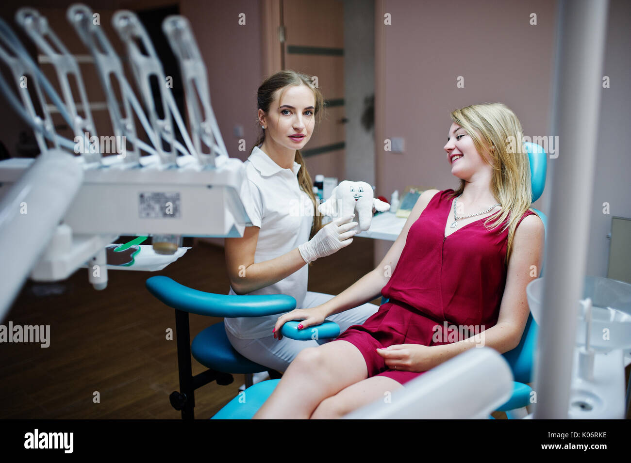 Gorgeous young orthodontist posing with big tooth model next to her ...