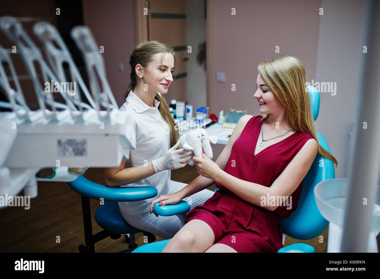 Gorgeous young orthodontist posing with big tooth model next to her ...