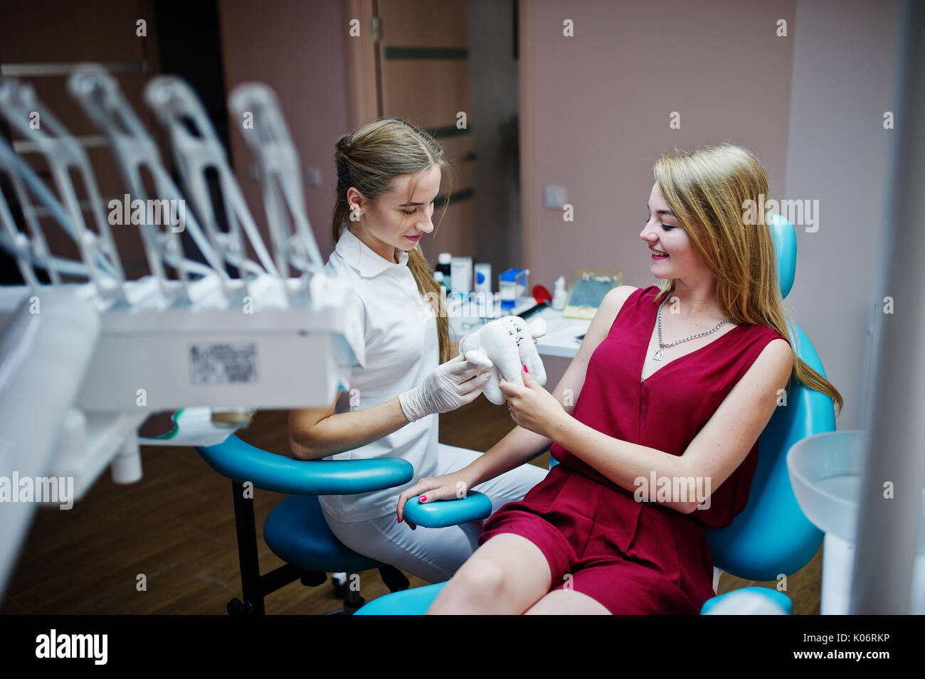 Gorgeous young orthodontist posing with big tooth model next to her ...