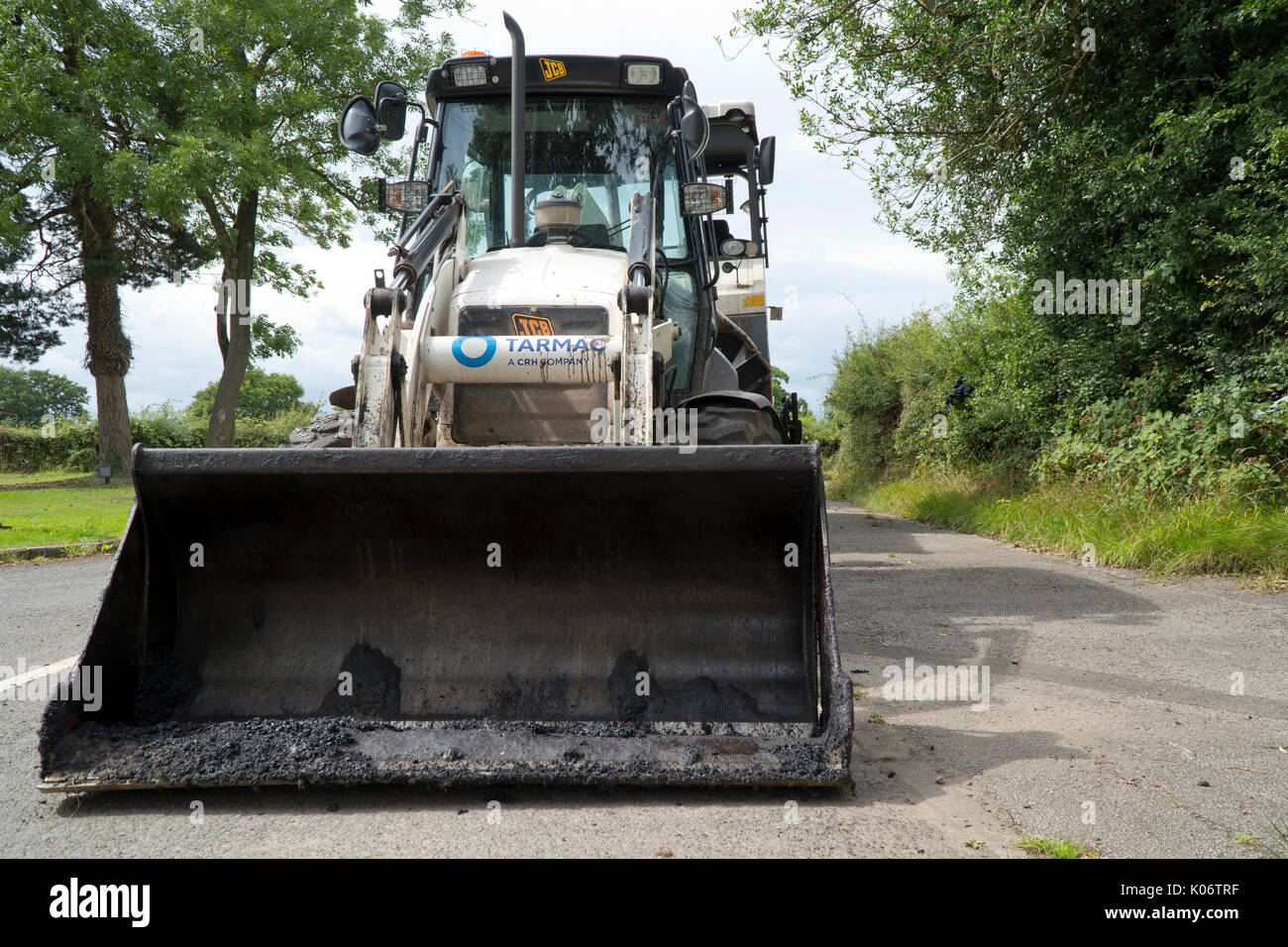Road repair digger parked in a country lane Stock Photo - Alamy