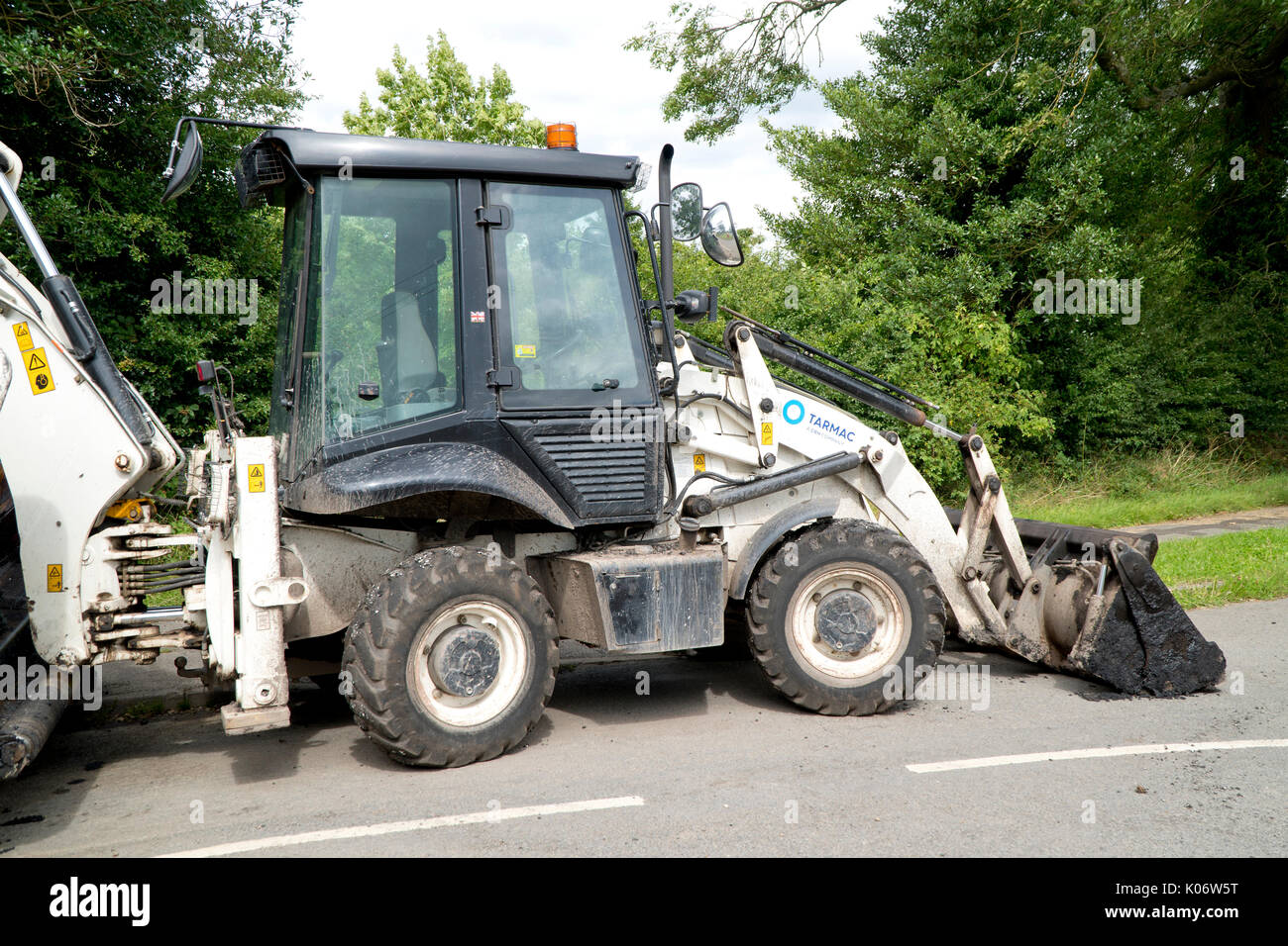 Road repair digger parked in a country lane Stock Photo - Alamy