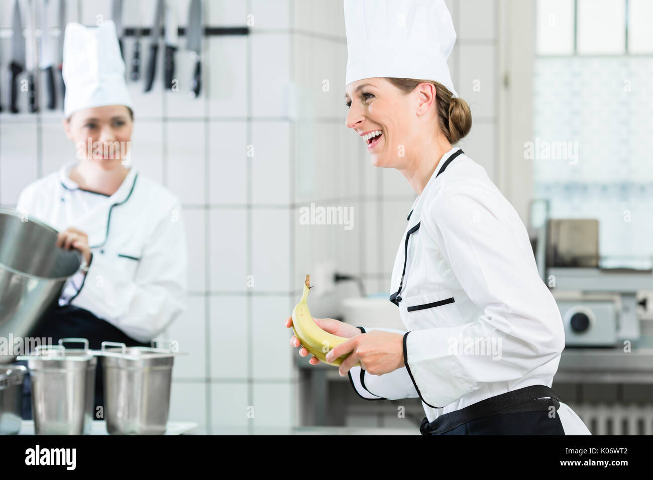 female chefs in commercial kitchen wearing white uniforms Stock Photo ...