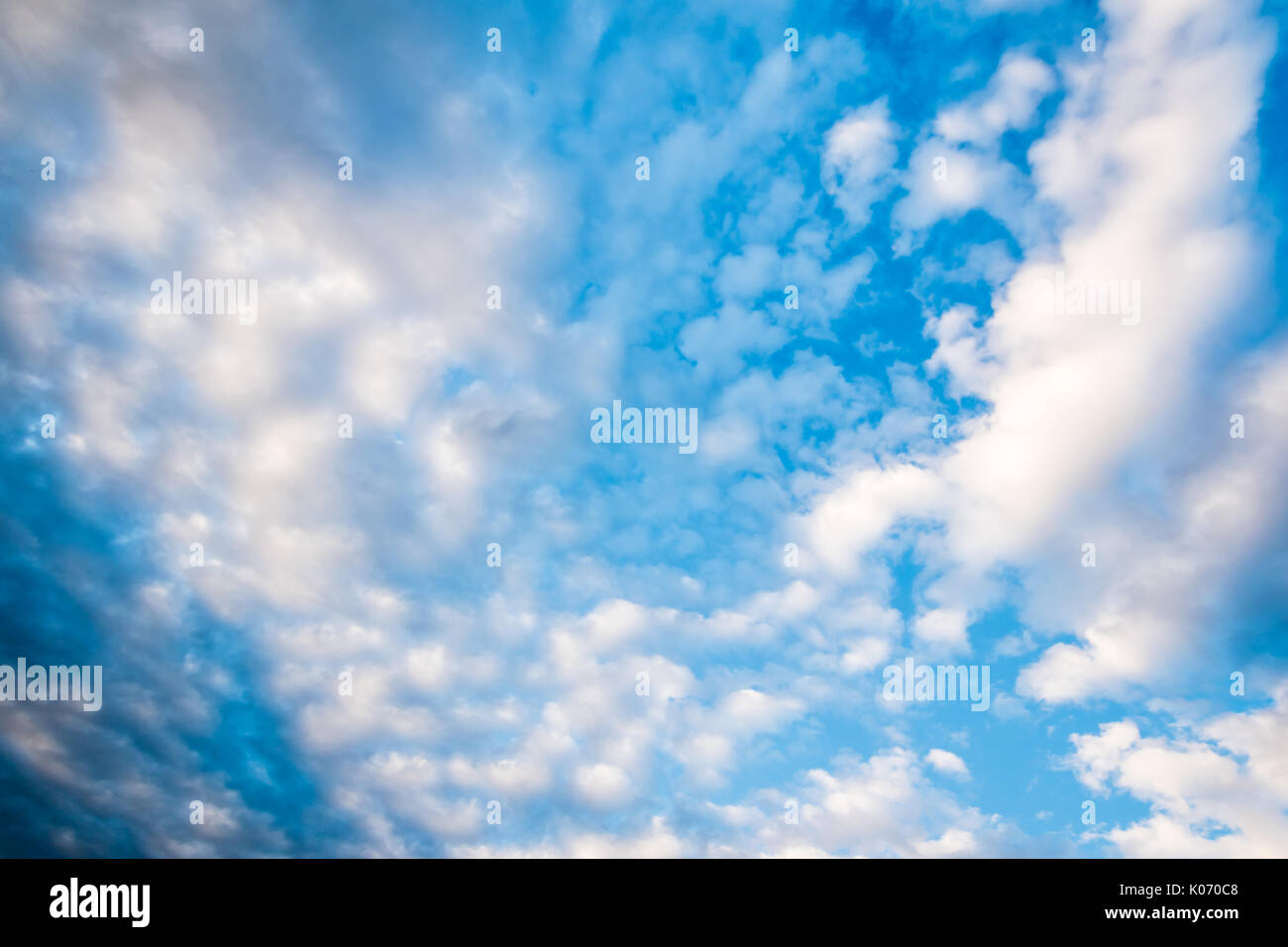 Nice blue sky with many small white clouds and two big clouds ...