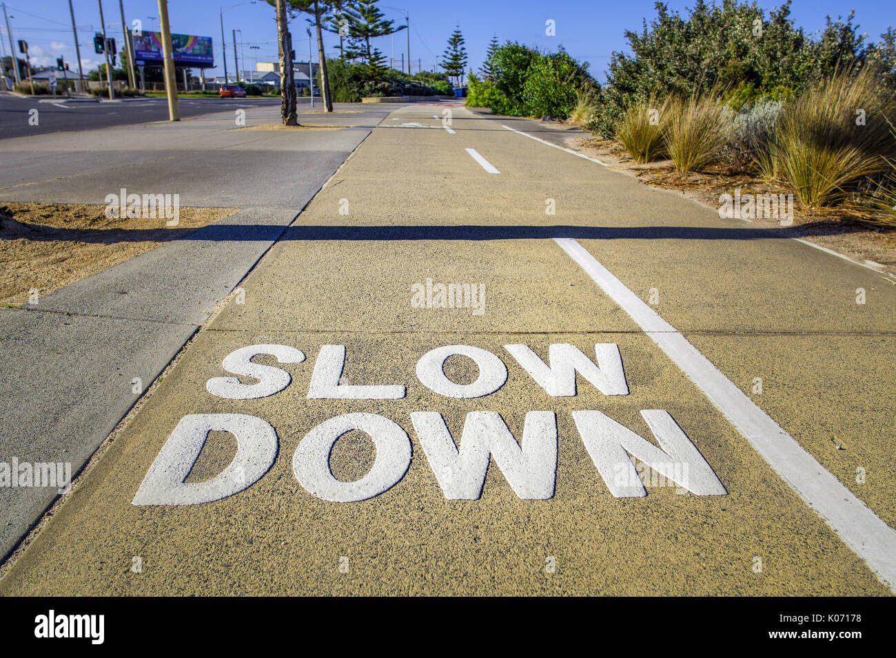 Big Slow Down sign on the footpath closeup Stock Photo - Alamy