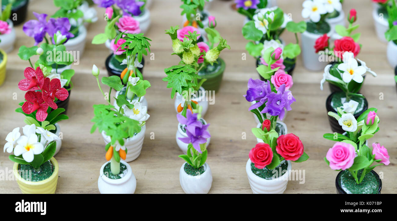 Small clay flower pots with many colors displayed on the shelf. This is ...