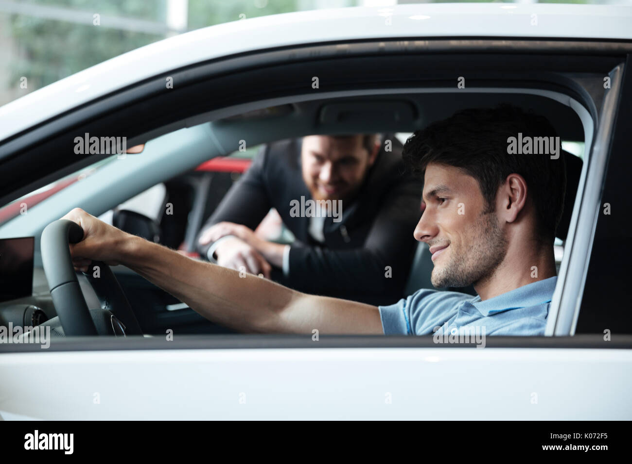 Young man testing his new car at the dealership Stock Photo - Alamy