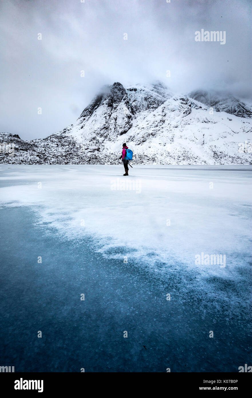 A photographer walking on a frozen lake, Lofoten Island, Norway Stock ...
