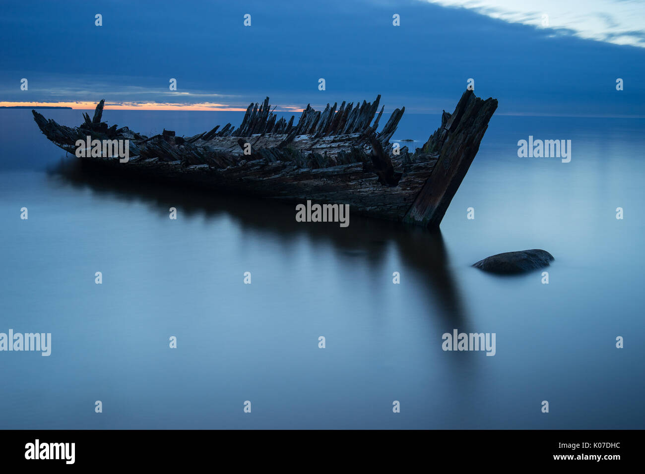 Old broken boat wreck on the shore, a frozen sea and beautiful blue ...