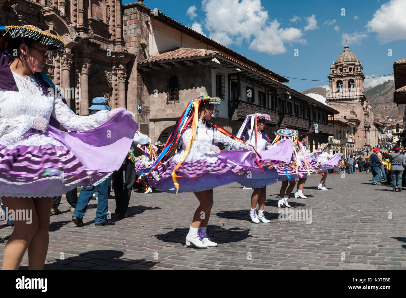 A dance troupe whirls along a cobbled street in the historic centre of ...