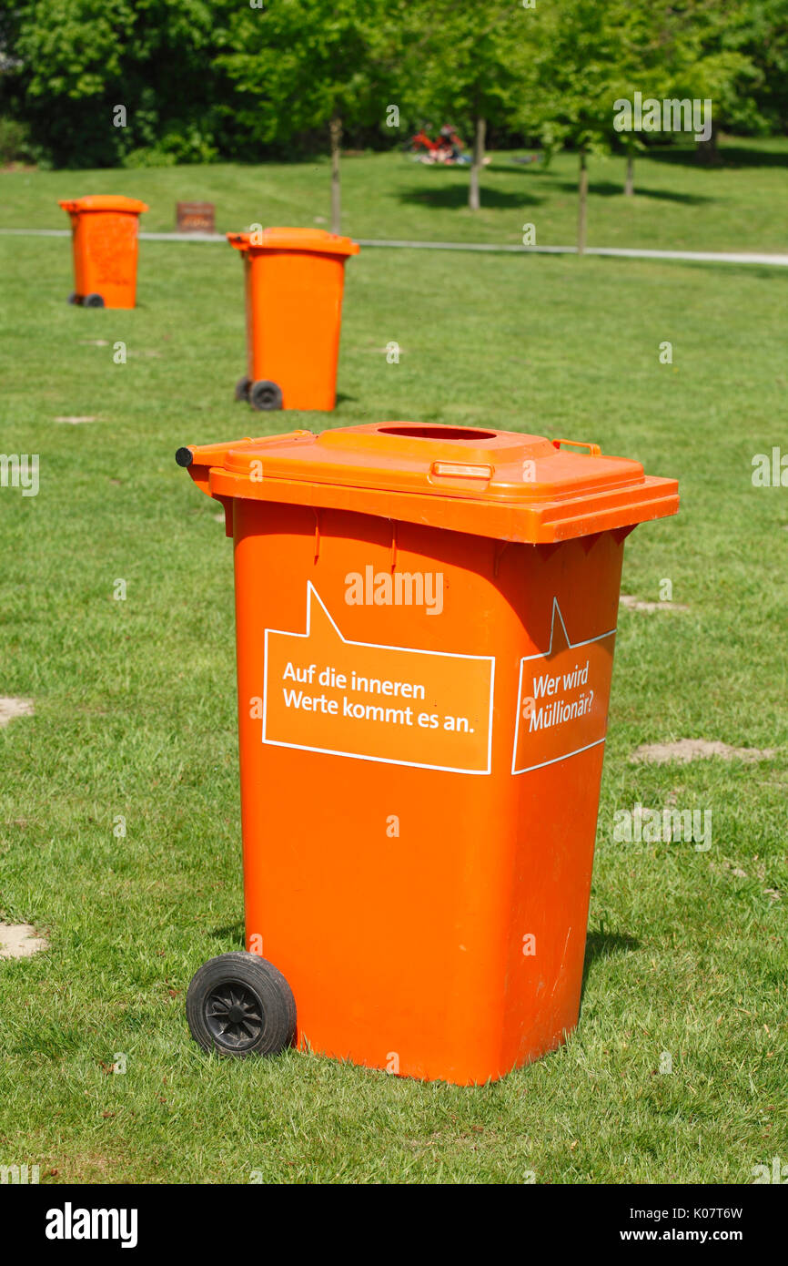 orange Trash Can, waste bin in a Park on a meadow Stock Photo - Alamy
