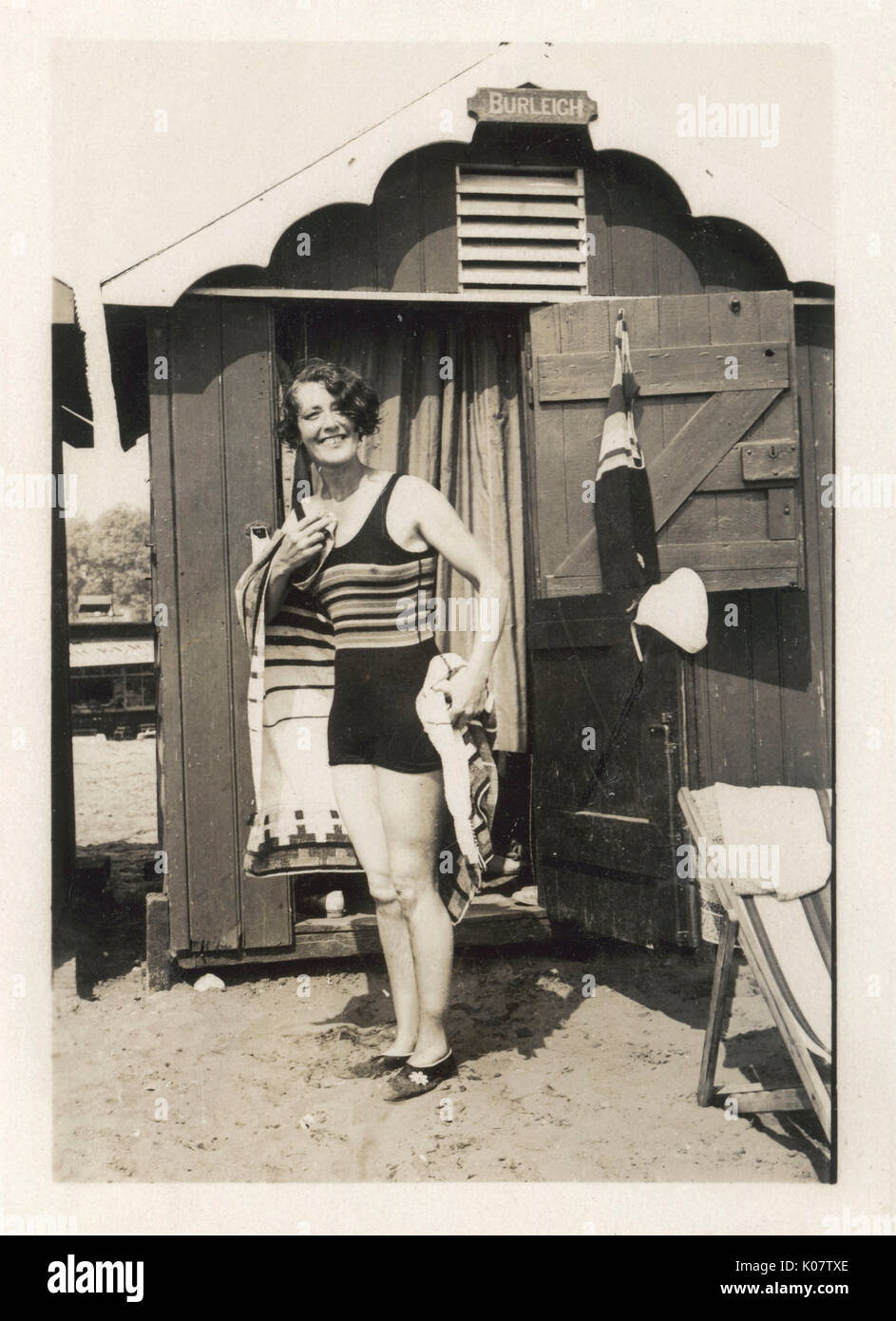 Woman drying herself after a dip in the sea outside her hut Stock Photo ...