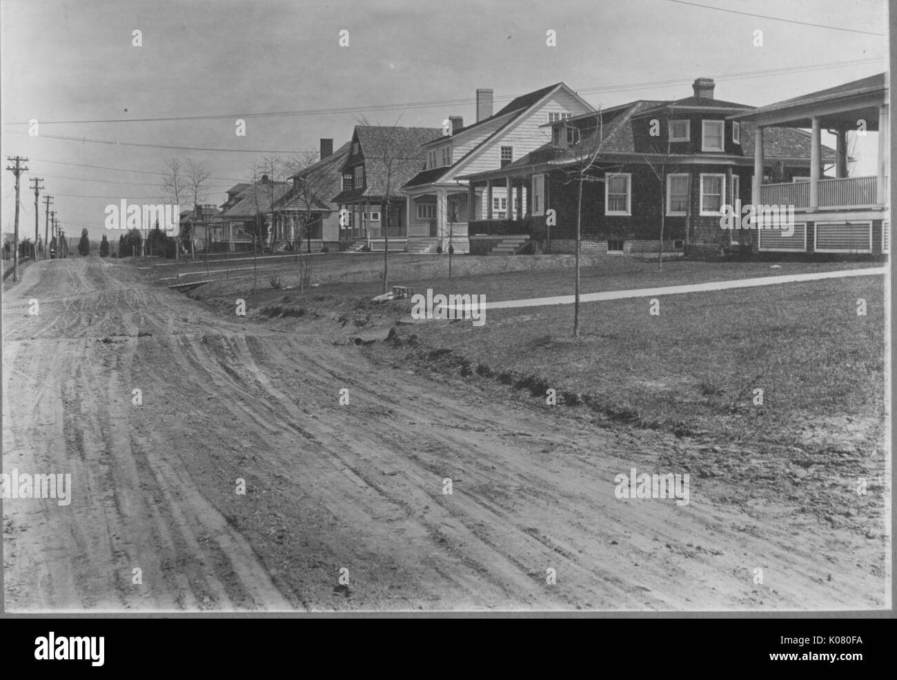Street-level shot of two-story brick houses along a dirt road houses ...