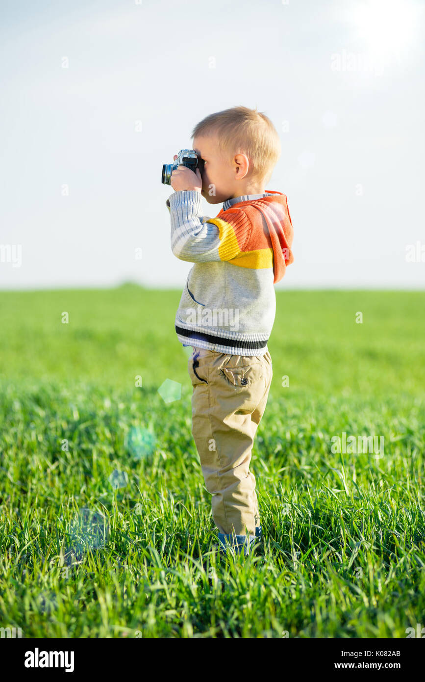 Little boy with an old camera shooting outdoor. Kid taking a photo ...