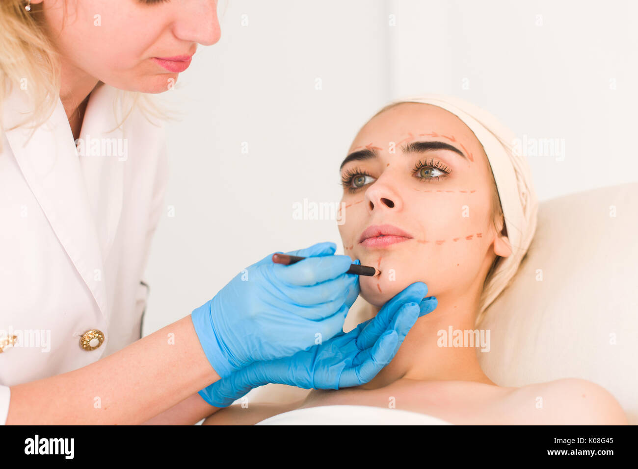 Plastic surgery concept. The surgeon painted on a woman dashed lines ...