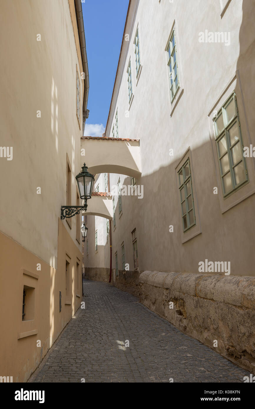 Narrow and empty cobblestone Thunovska Street and old buildings at the ...