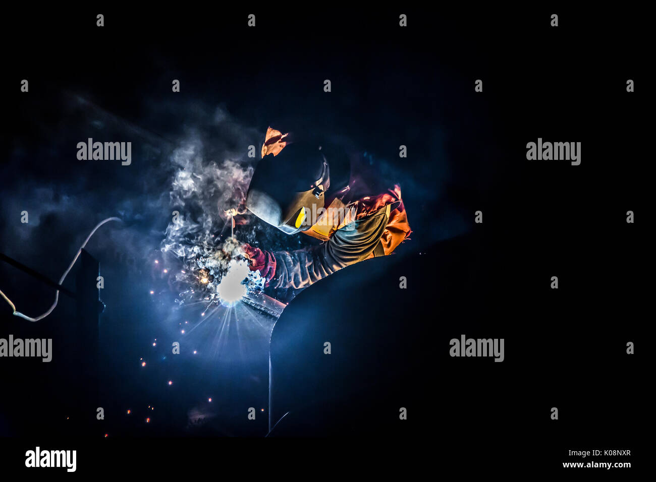 Welder worker with protective mask welding metal trunk pipeline in ...