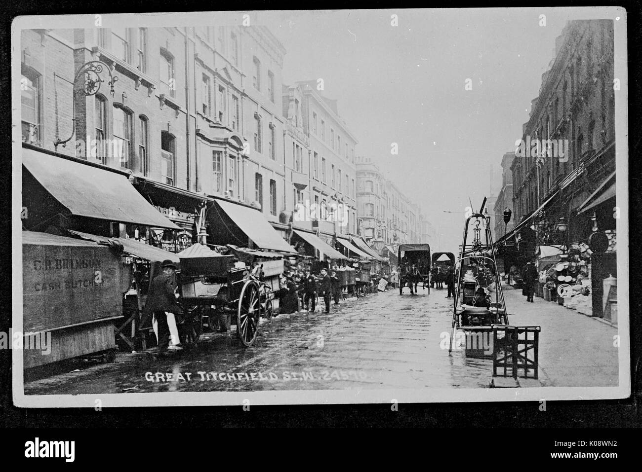 Shops in Great Titchfield Street, London on a wet day. Date: circa 1905 ...